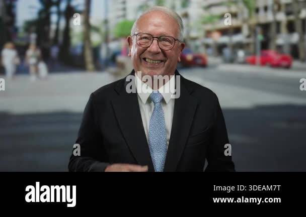 Senior man in business suit smiling on a busy city street, showcasing a ...