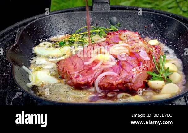 wine pour deglazing pan around seared steak, onions and garlic ...