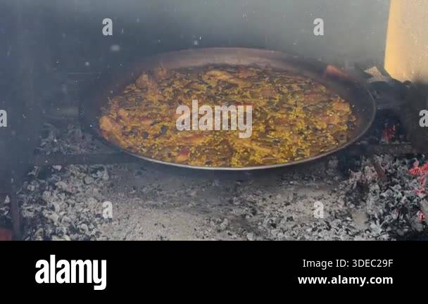 Close-up of traditional Spanish paella simmering in a wood-fired oven ...