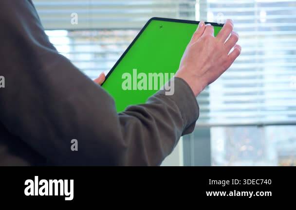 Woman using a tablet with green screen and tracking markers, swiping on ...