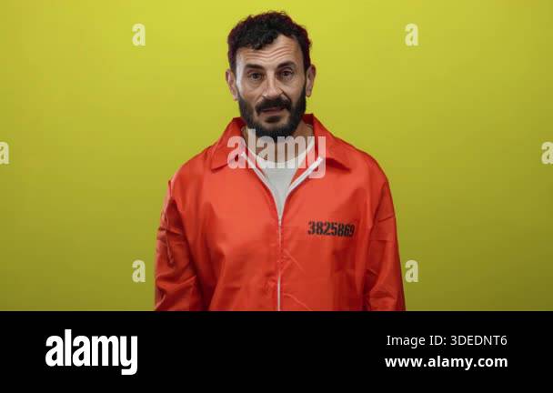 Hispanic man with beard in orange prison jumpsuit gestures against ...