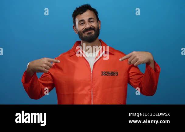 Hispanic man with beard in orange prison jumpsuit poses confidently ...