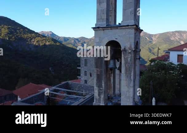 A rotating shot shows a stone Orthodox bell tower with bells during ...