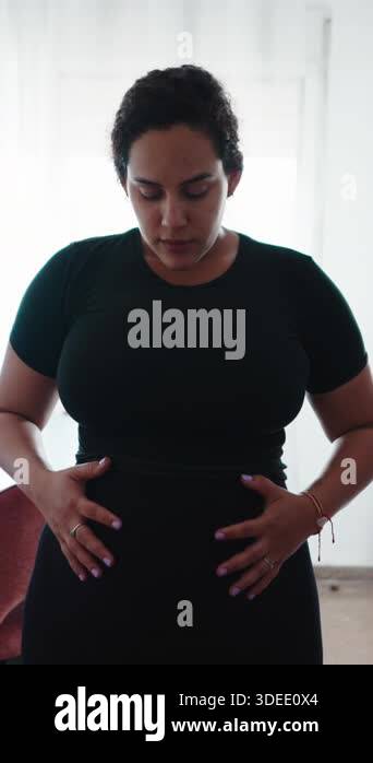 Mother-to-be dressed in black tenderly caressing her abdomen while in ...