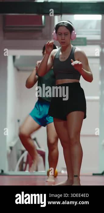 Two determined young women training together practicing punches and ...