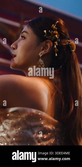 Young Asian woman dressed in a traditional dress and gold jewelry ...