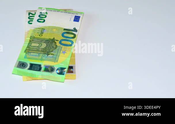 Person organizes euro banknotes on a table, dividing cash into two ...