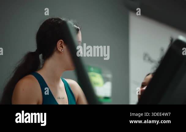 Athletic woman focused on her cardio workout on the elliptical machine ...