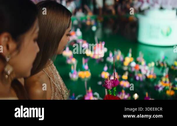 Beautiful young thai women releasing their krathongs into the water ...