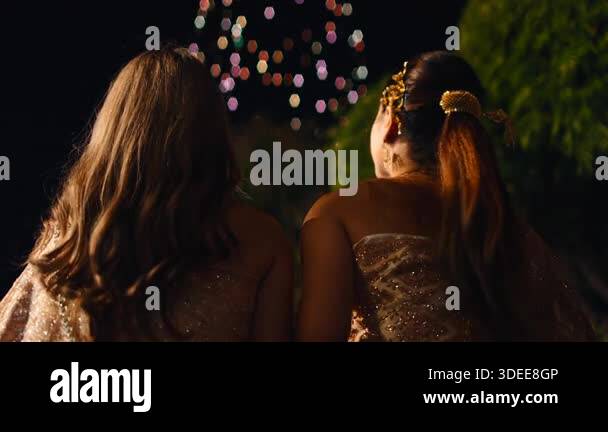 Two young thai women in traditional clothing watching fireworks during ...