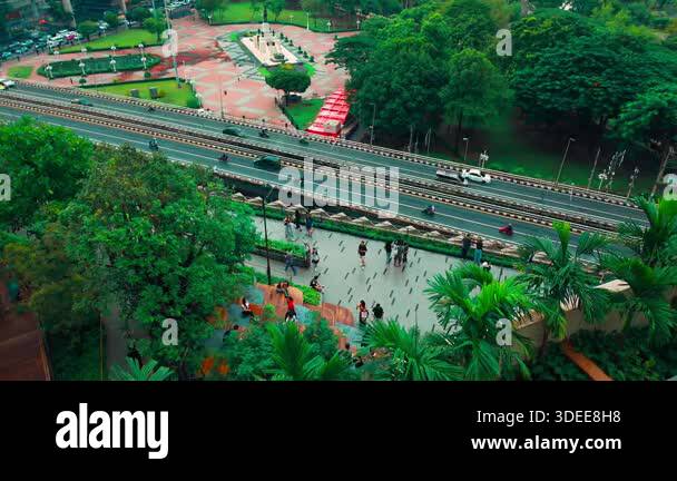 people walking on rooftop of modern mall with artificial green elevated ...