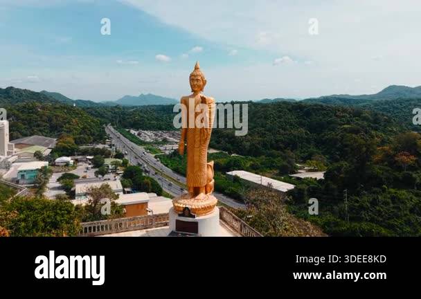 Aerial view of a golden standing buddha statue overlooking a busy ...