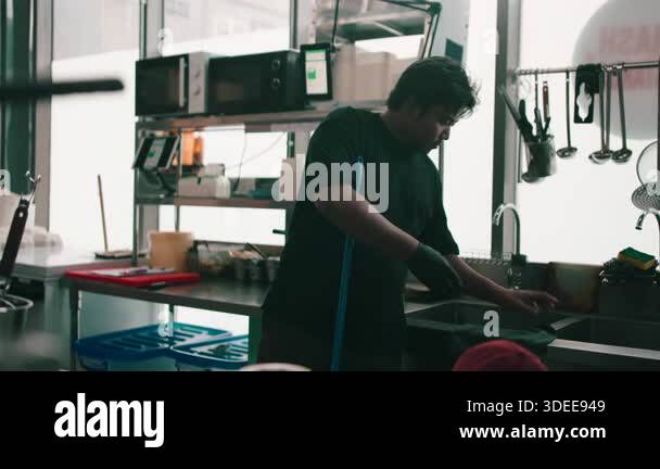 Professional kitchen staff cleaning and preparing for service in a busy ...