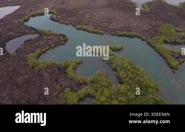 Turquoise inlets winding through dark volcanic rock and lagoon ...
