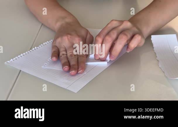 hands tearing spiral notebook page with careful peel and smoothing edge ...