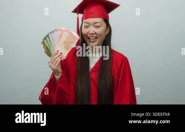 Woman in red graduation gown holding philippine pesos against white ...