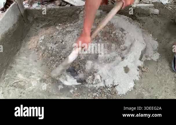 4K footage of construction worker mixing sand and cement with a hoe ...