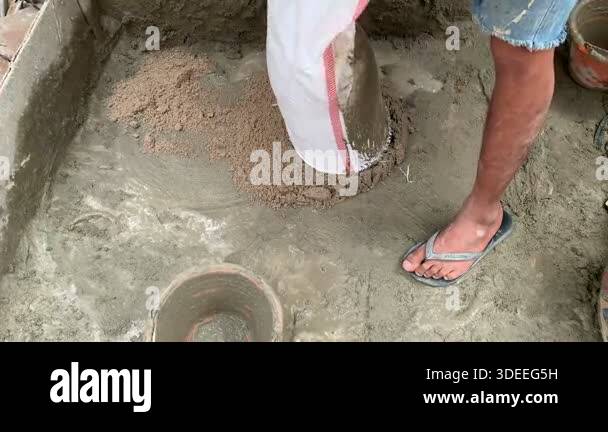 Construction worker pours sand from a bag for concrete mixing. Low ...