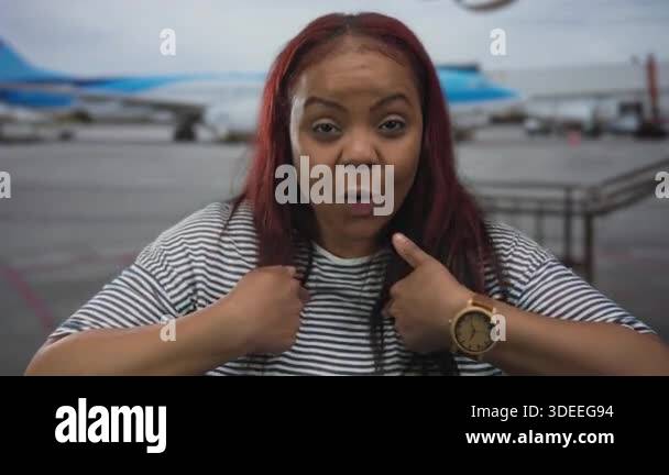 Woman with hands on cheeks in a surprised smile and red hair framing ...