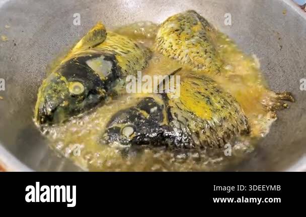 Deep Frying Seasoned Carp Fish Heads in a Hot Wok with Bubbling Oil ...