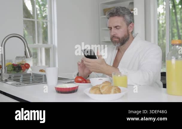 Healthy breakfast in morning. Mature man eating breakfast in kitchen ...