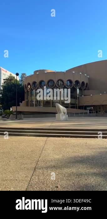 Round concrete building with sculpture and glass facade in San Jose ...