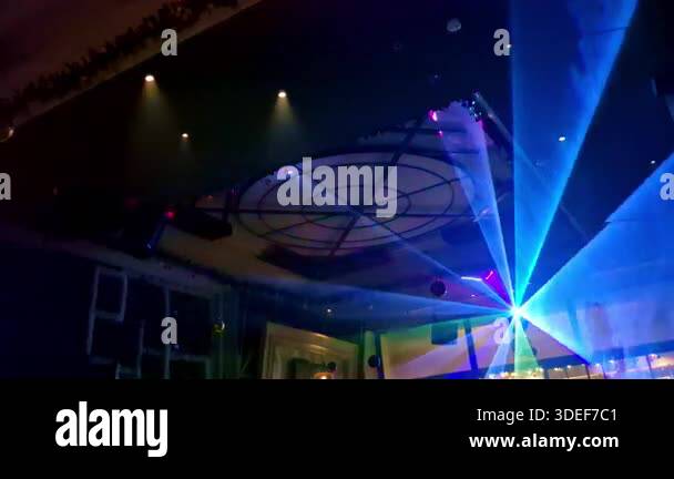 A wide view shows vivid blue, green, and purple laser beams radiating ...