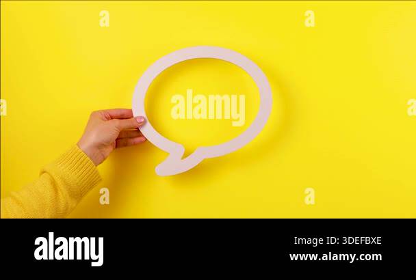 4K footage of a hand holding a speech or dialogue bubble symbol against ...