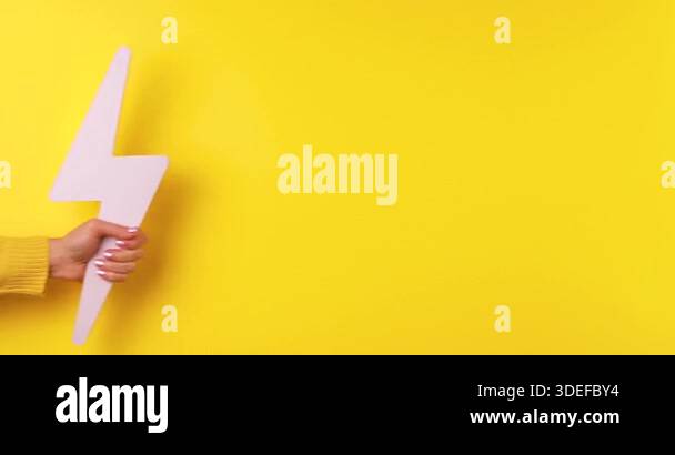 4K footage of a hand making a lightning bolt sign against a yellow ...