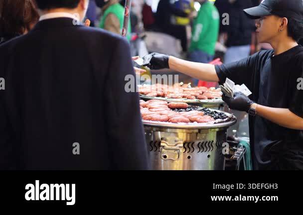 Merchant sells sausages and provides change Stock Video Footage - Alamy