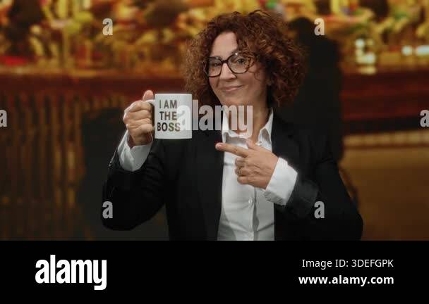 Woman smiling at fair holding cup with boss text playfully pointing ...