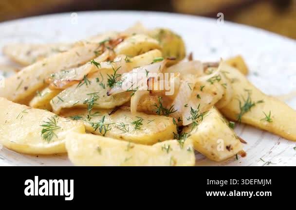 Fried potatoes with mushrooms, onion, meat, pickles on the plate ...