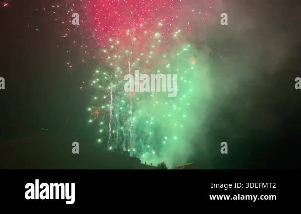 Multiple fireworks exploding with bright colors and thick smoke during ...