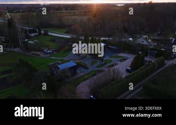 Aerial dusk view of private estate with brick driveway and outbuilding ...