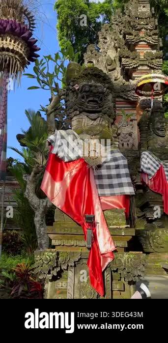 Traditional Balinese stone guardian statues at Hindu temple entrance in ...