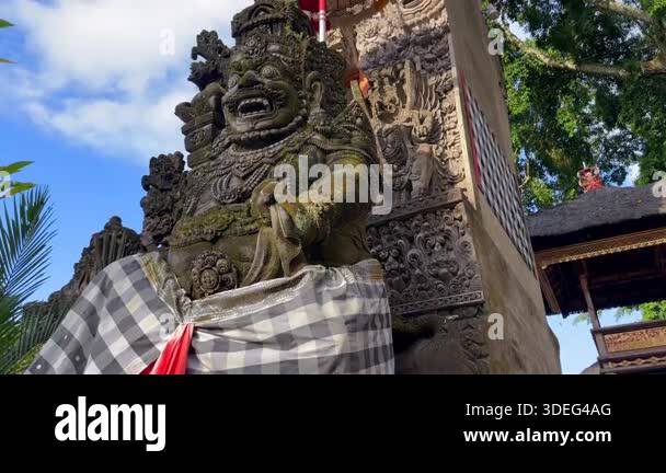 Traditional Balinese stone guardian statues at Hindu temple entrance in ...