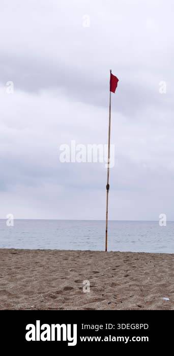 Red flag waving, prohibiting swimming in sea due to bad weather. Flag ...