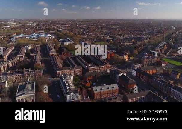 Aerial sunrise flyover of Liverpool, UK shows terraces, tree lined ...