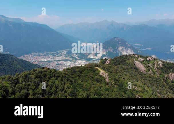 Rocky mountain ridge rising above valley with town and alpine peaks ...