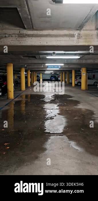 Flooded underground garage with water puddles on floor after rain. Wet ...