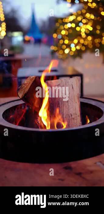 Warm flames dancing on burning logs in an outdoor fire pit with bright ...