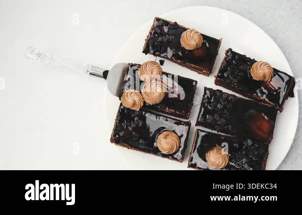 Rich chocolate cake slices with cream swirls on a white plate served ...