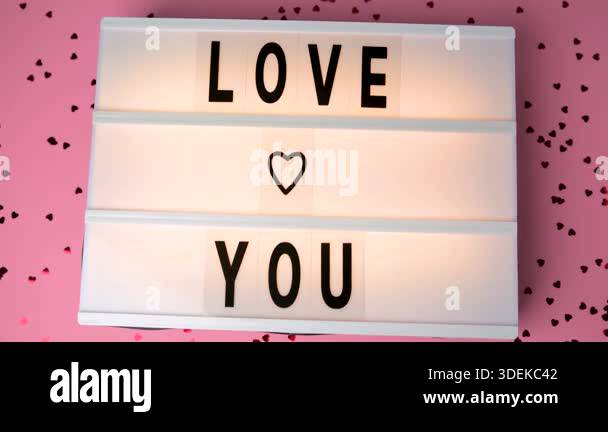 Light box displaying "Love You" message with hearts on a pink ...