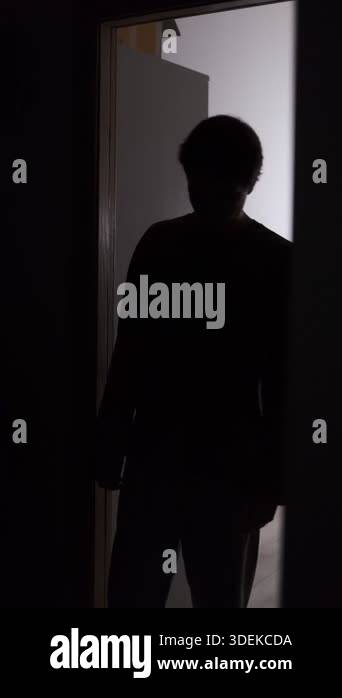 Man steps into dark corridor and breaks down in doorway, covering face ...