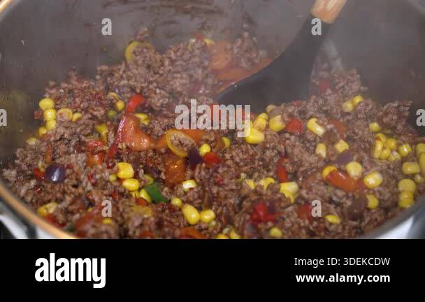 A pot of chili con carne simmers with minced meat, beans, corn, and ...