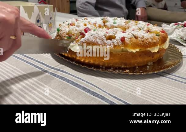 Hands cutting a traditional Spanish Roscon de Reyes to share with ...