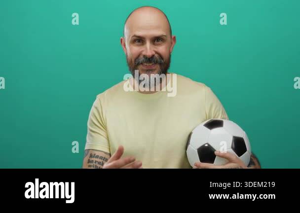 Man whispering secret holding soccer ball against green background ...
