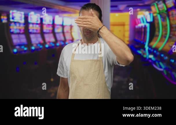 Blond man in apron covers eyes with hand at casino building ...