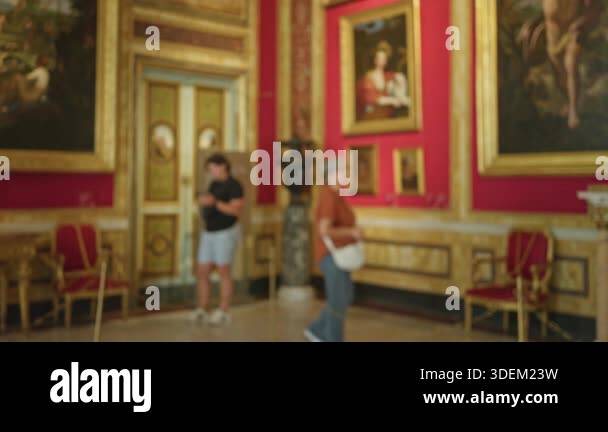 Ornate museum interior with gilded frames and red walls, defocused ...
