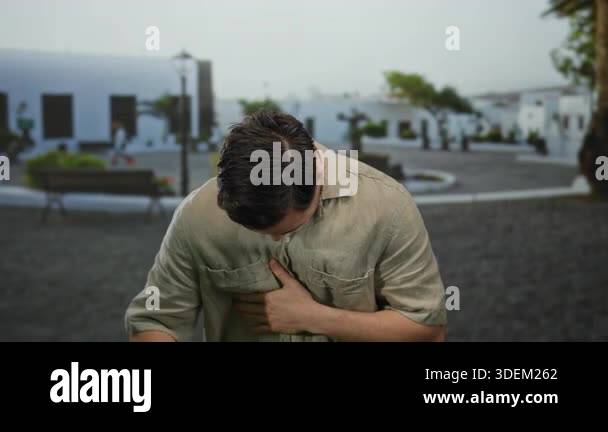 Young man with beard smiling joyfully on a sunny street in a city ...